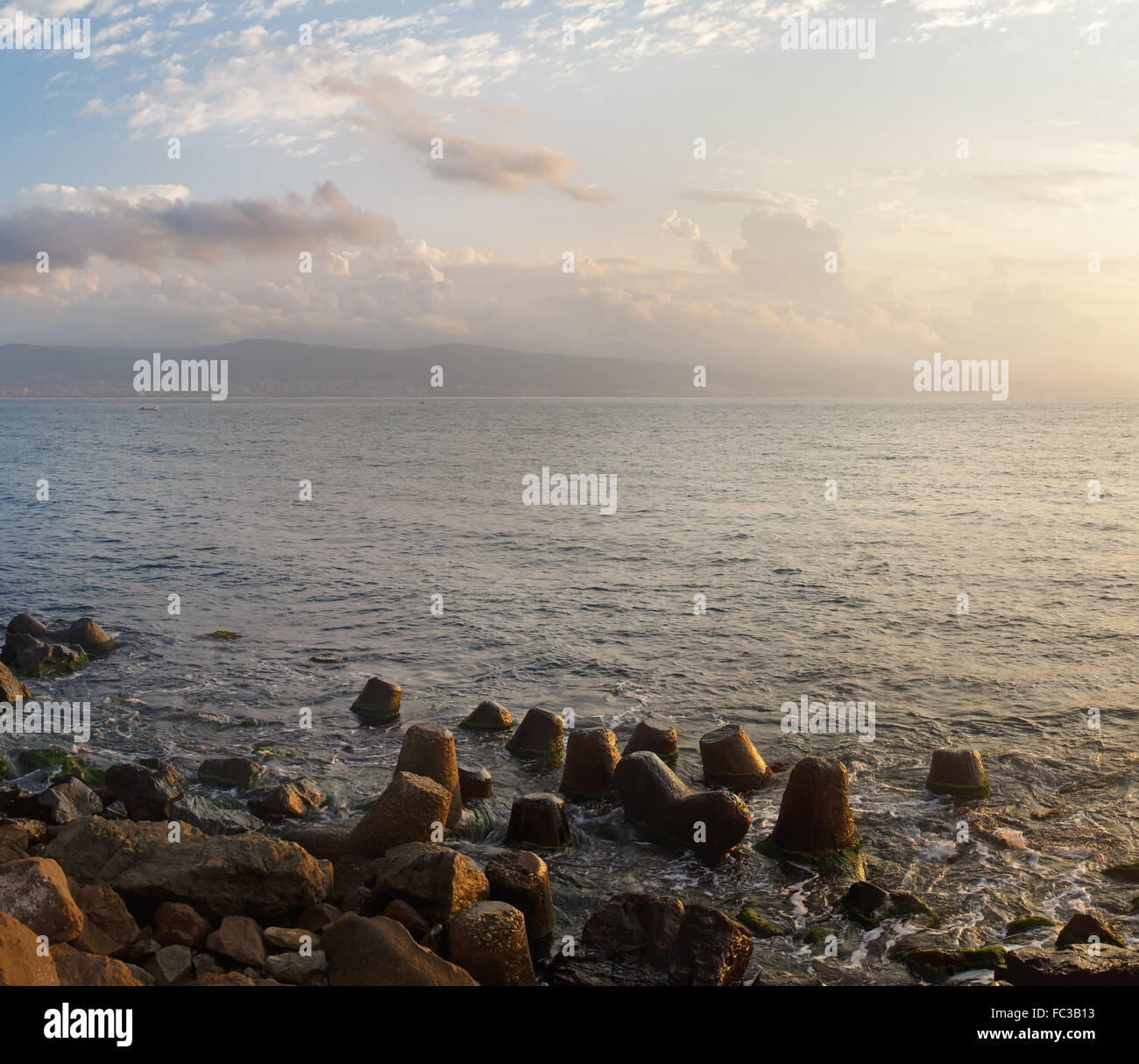 Morning seascape. Calm sea, cloudy sky and mountains on the horizon ...
