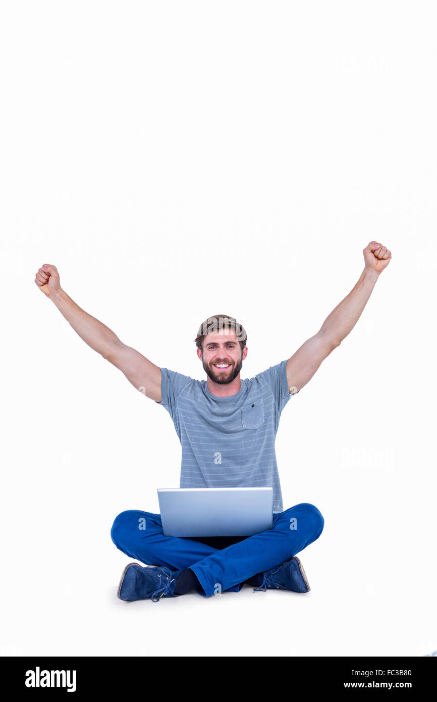 Happy handsome man cheering behind his computer Stock Photo - Alamy