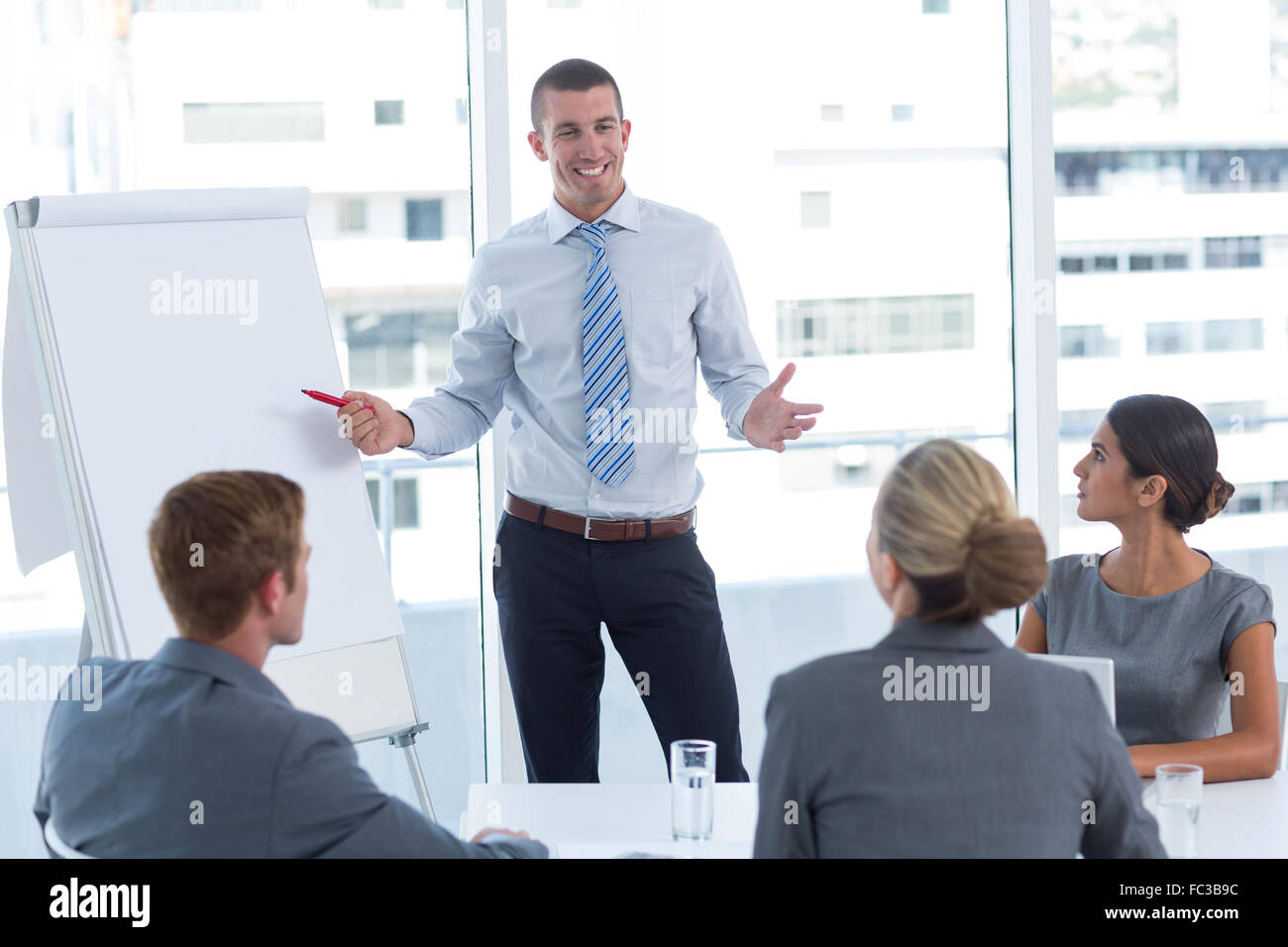Manager presenting whiteboard to his colleagues Stock Photo - Alamy