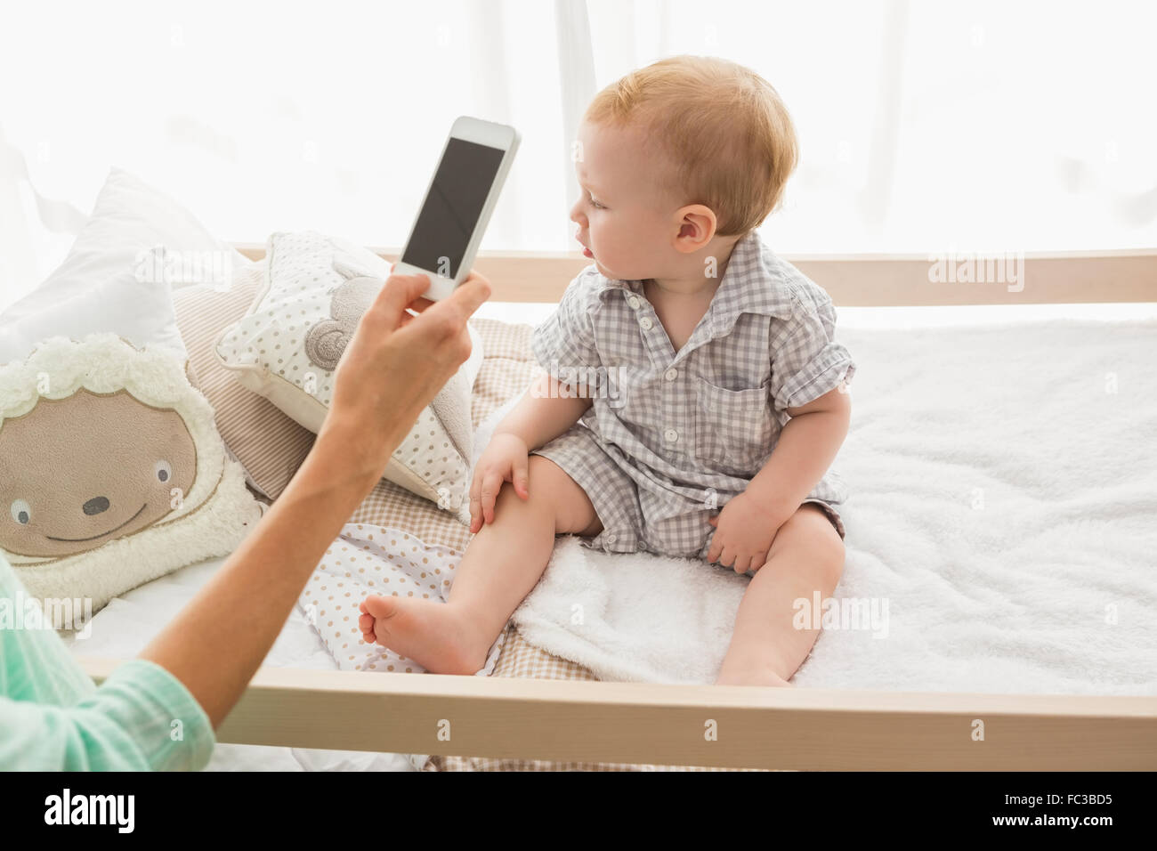 Happy mother using her phone with her baby boy Stock Photo - Alamy
