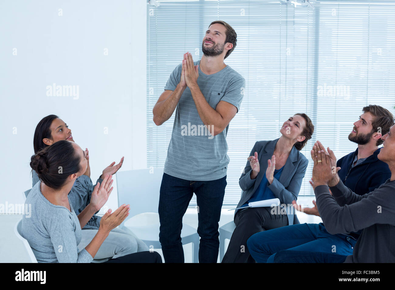 Rehab group applauding delighted man standing up Stock Photo - Alamy