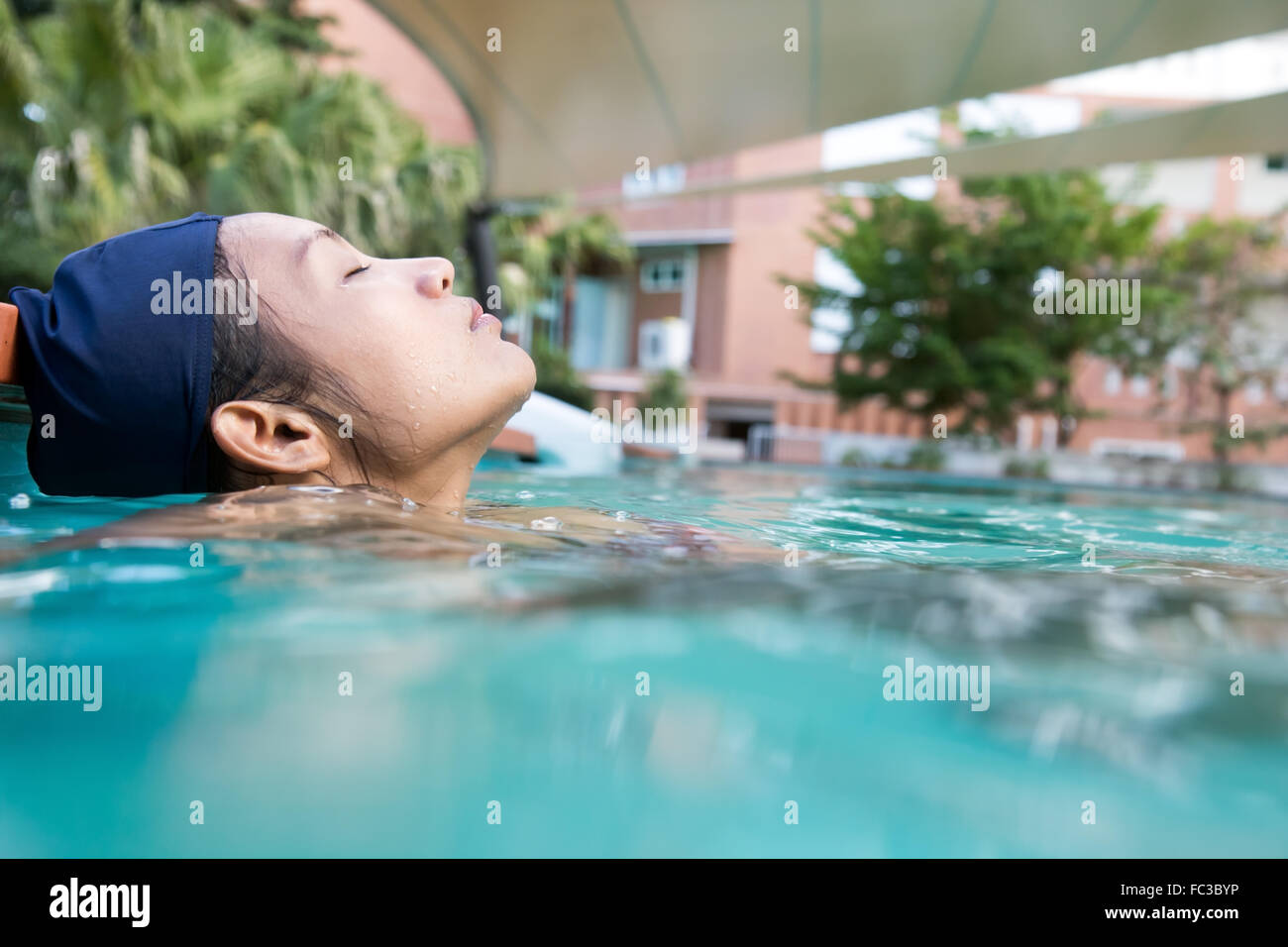 Girl relaxing in swimming pool Stock Photo - Alamy