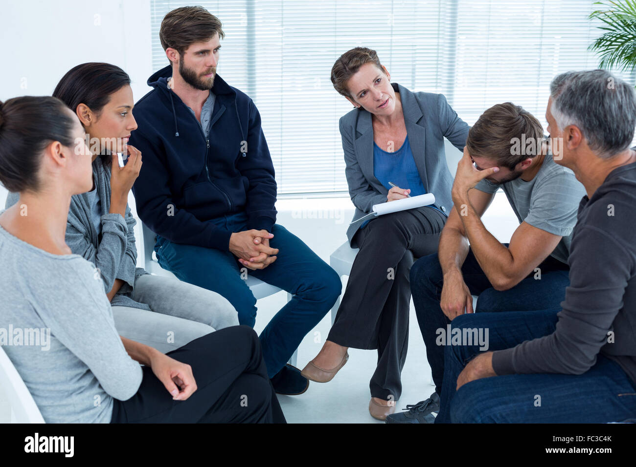 Concerned woman comforting another in rehab group Stock Photo - Alamy