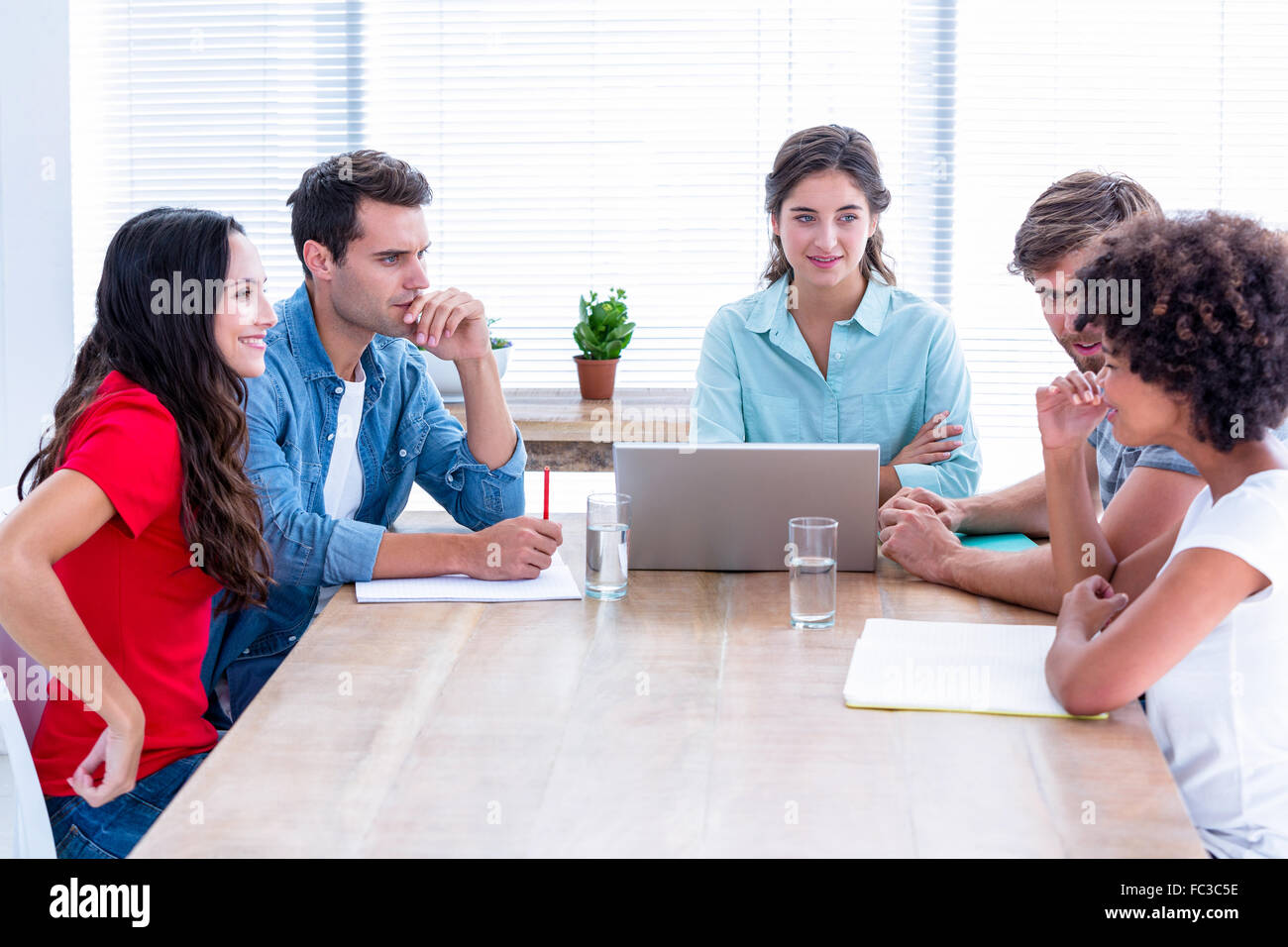 Creative business people using laptop in meeting Stock Photo - Alamy