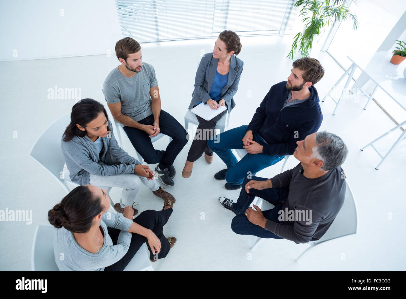 Group therapy in session sitting in a circle Stock Photo - Alamy