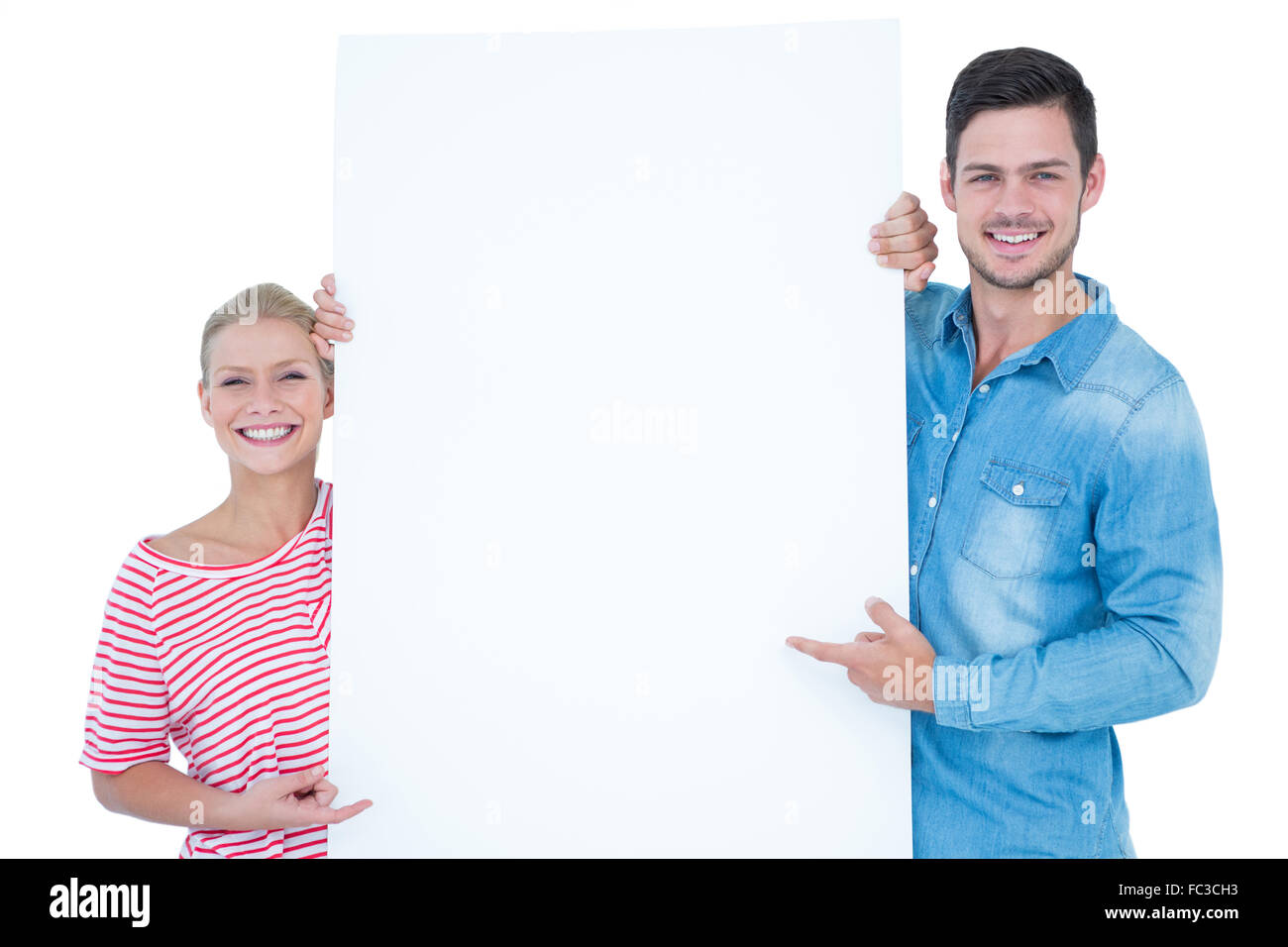 Smiling couple pointing at blank sign in their hands Stock Photo - Alamy