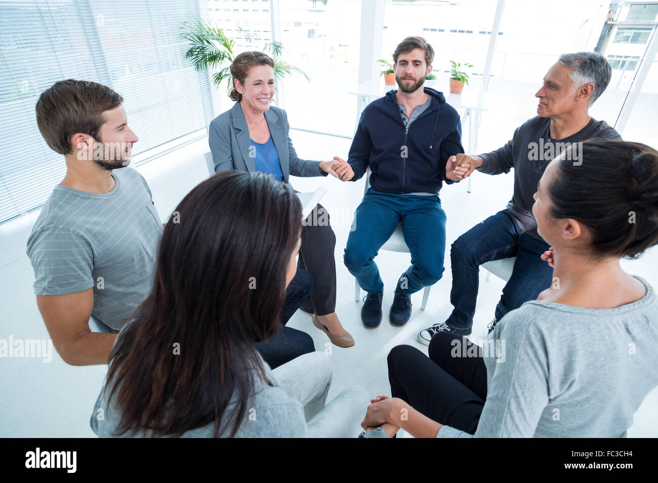 Group therapy in session sitting in a circle Stock Photo - Alamy
