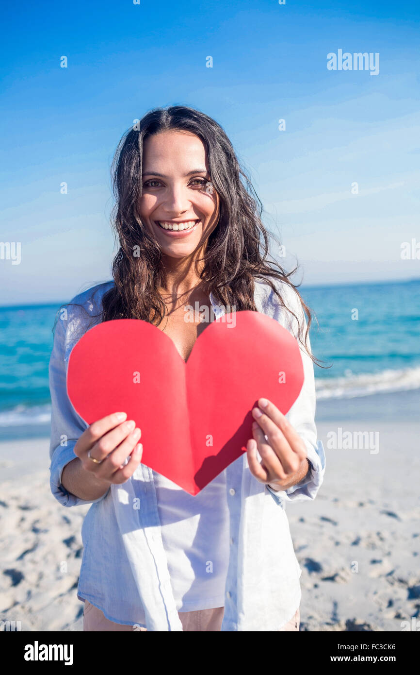 Smiling woman holding heart card at the beach Stock Photo - Alamy Smiling woman holding heart card at the beach Stock Photo - Alamy