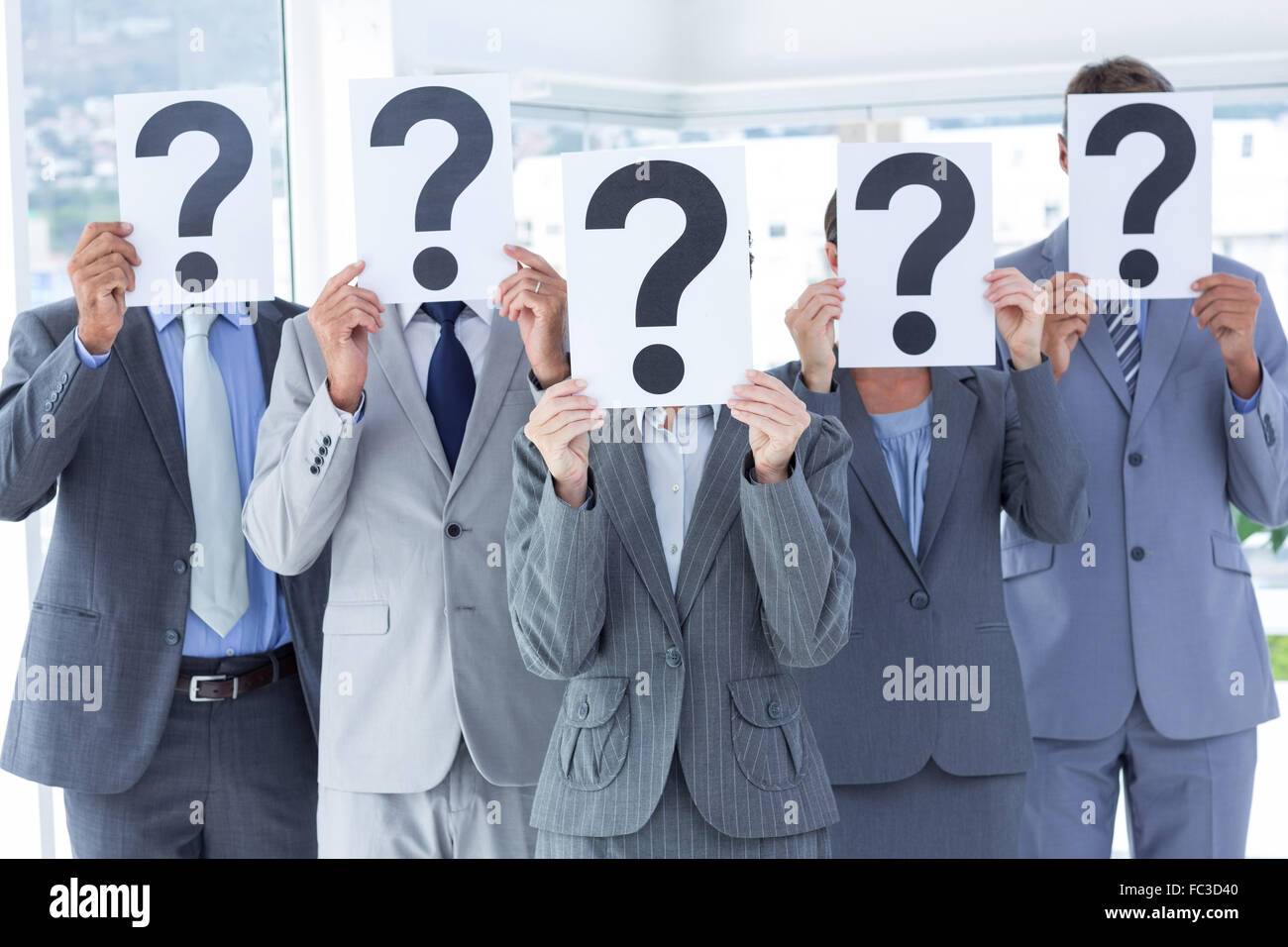 Business colleagues hiding their face with question mark sign Stock ...