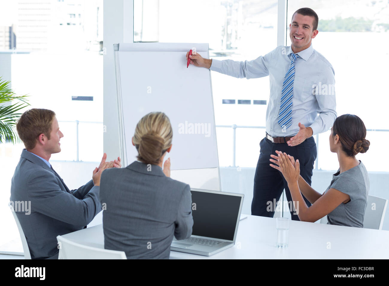 Manager presenting whiteboard to his colleagues Stock Photo - Alamy