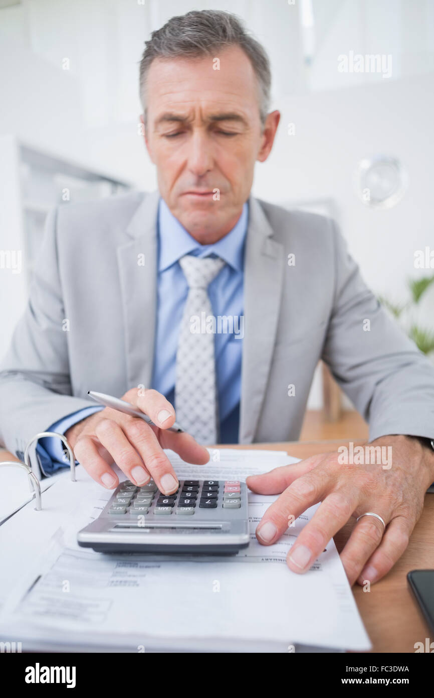Businessman using calculator to calculate finance Stock Photo - Alamy