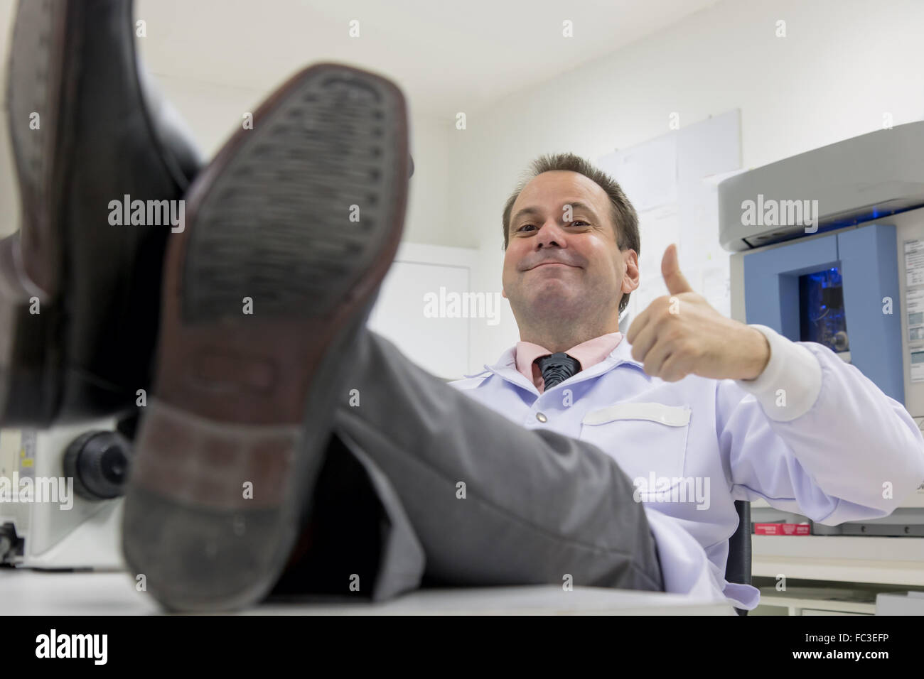 Successful doctor in a laboratory has his feet on the desk Stock Photo ...