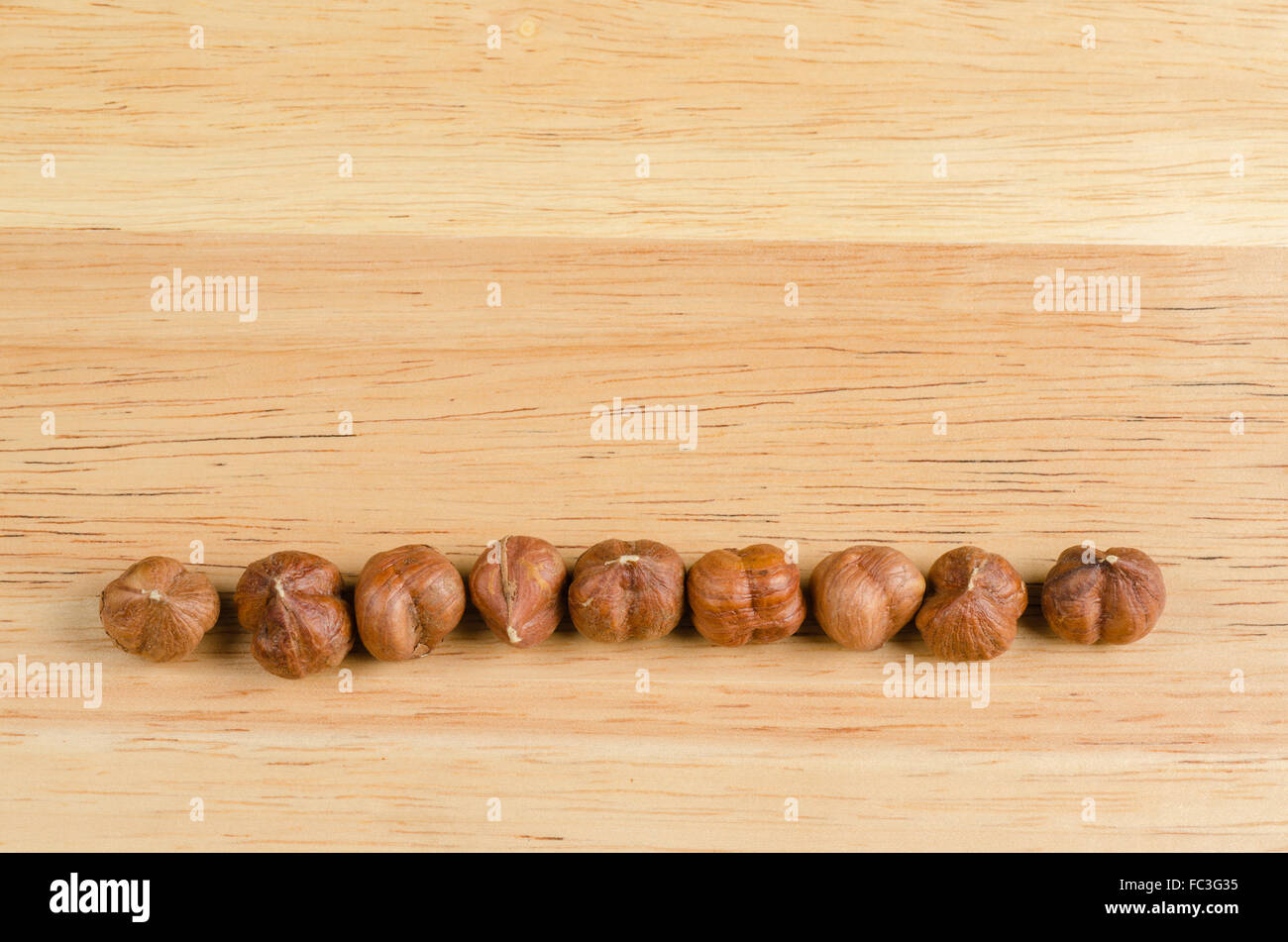 toasted hazelnuts without shells, on wood, background Stock Photo - Alamy