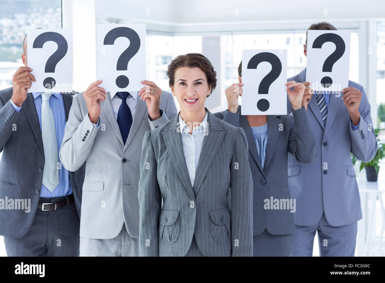 Business colleagues hiding their face with question mark sign Stock ...