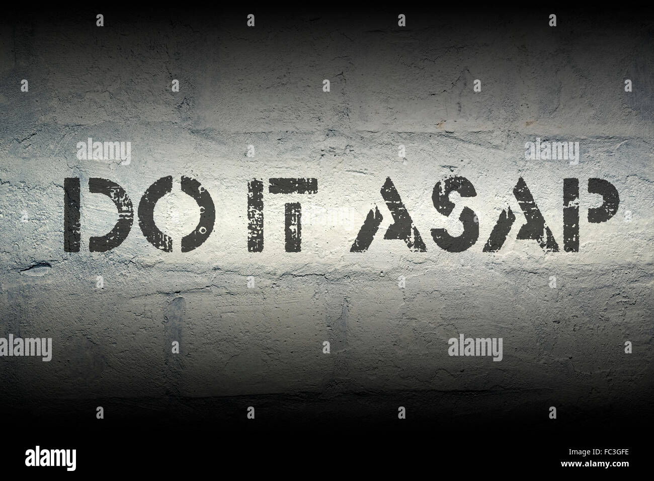 do it ASAP stencil print on the grunge white brick wall Stock Photo - Alamy