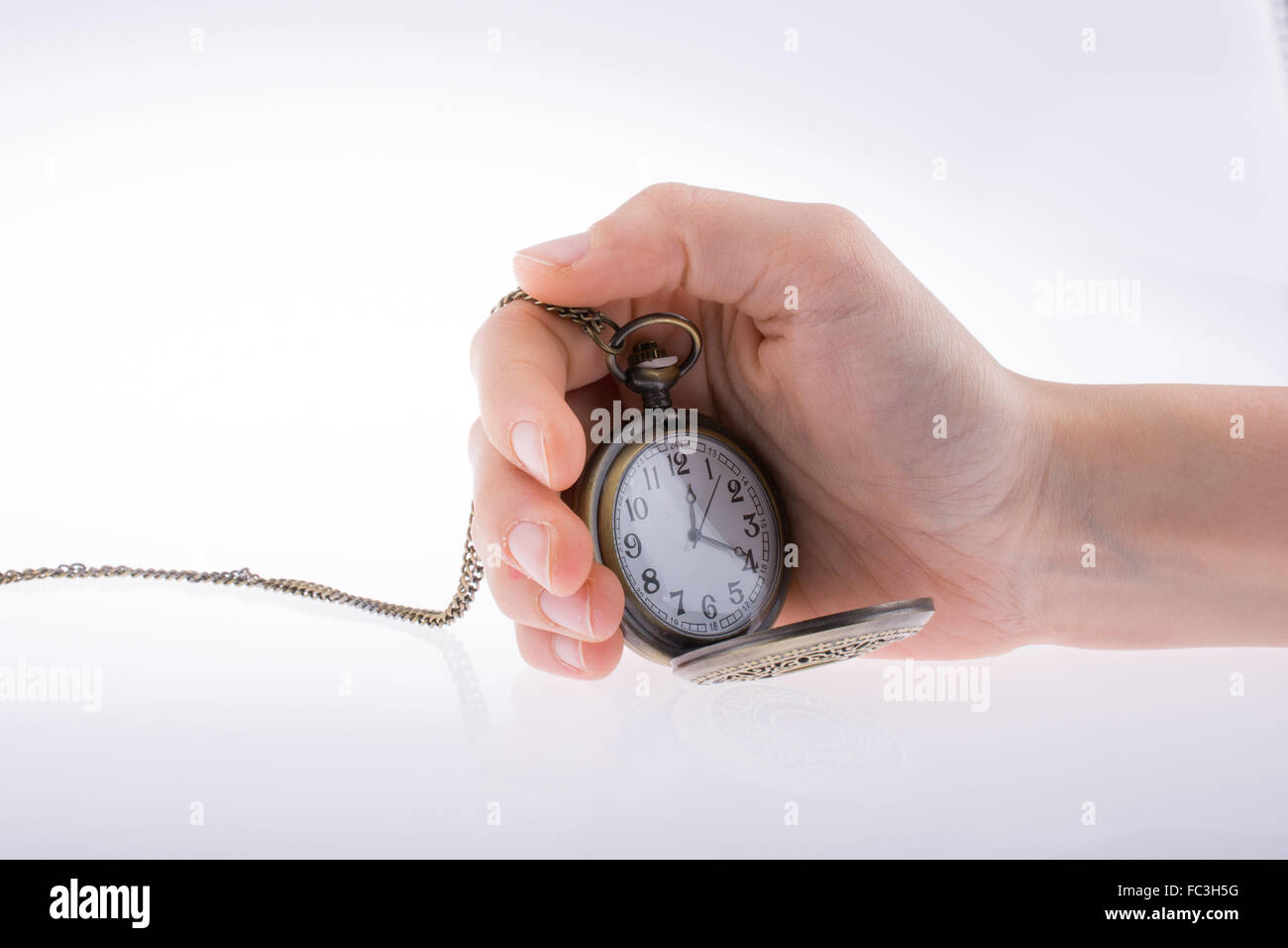 Hand holding a Pocket watch in hand Stock Photo - Alamy