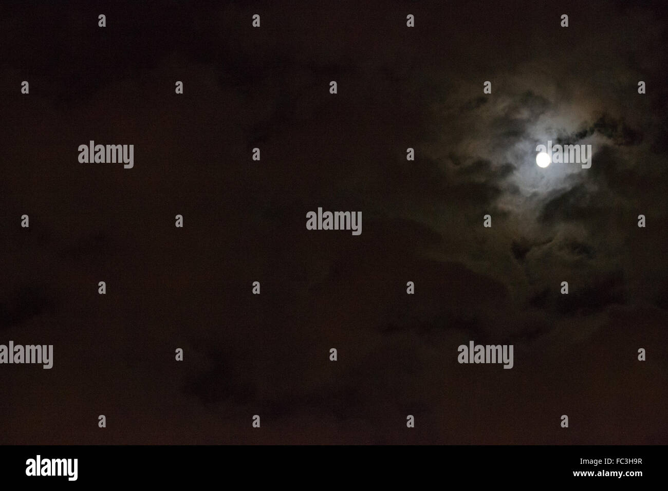 Moon between clouds Stock Photo - Alamy