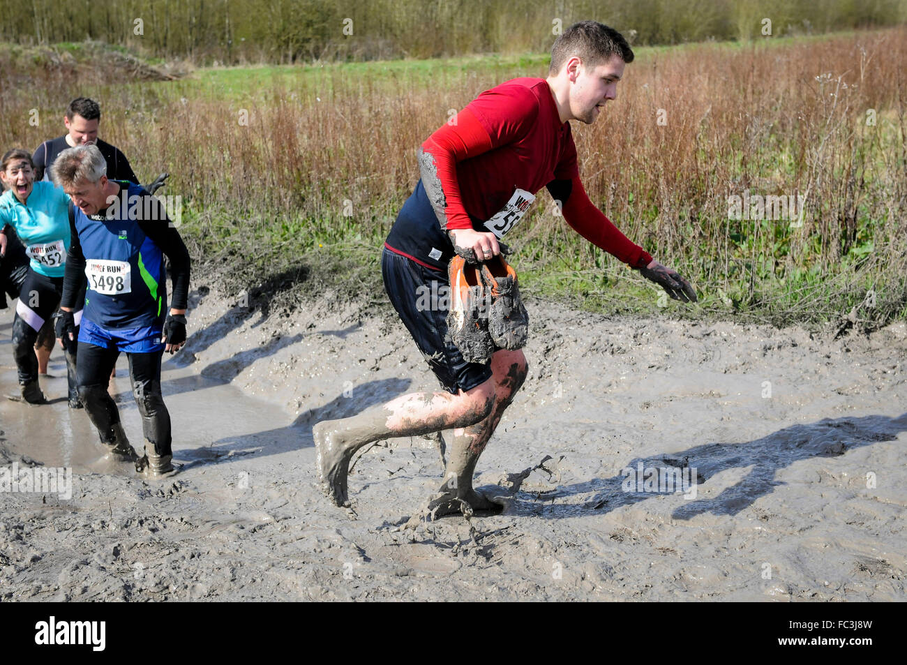 Runners crossing muddy obstacles at obstacle course race, UK Stock ...