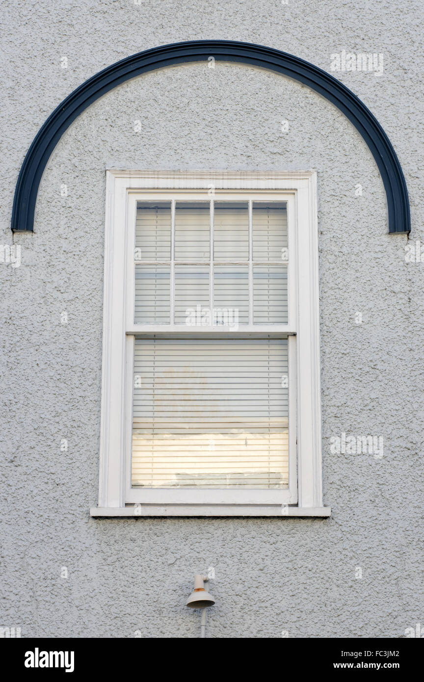 Wooden rectangular window with curved eyebrow accent on stucco wall ...
