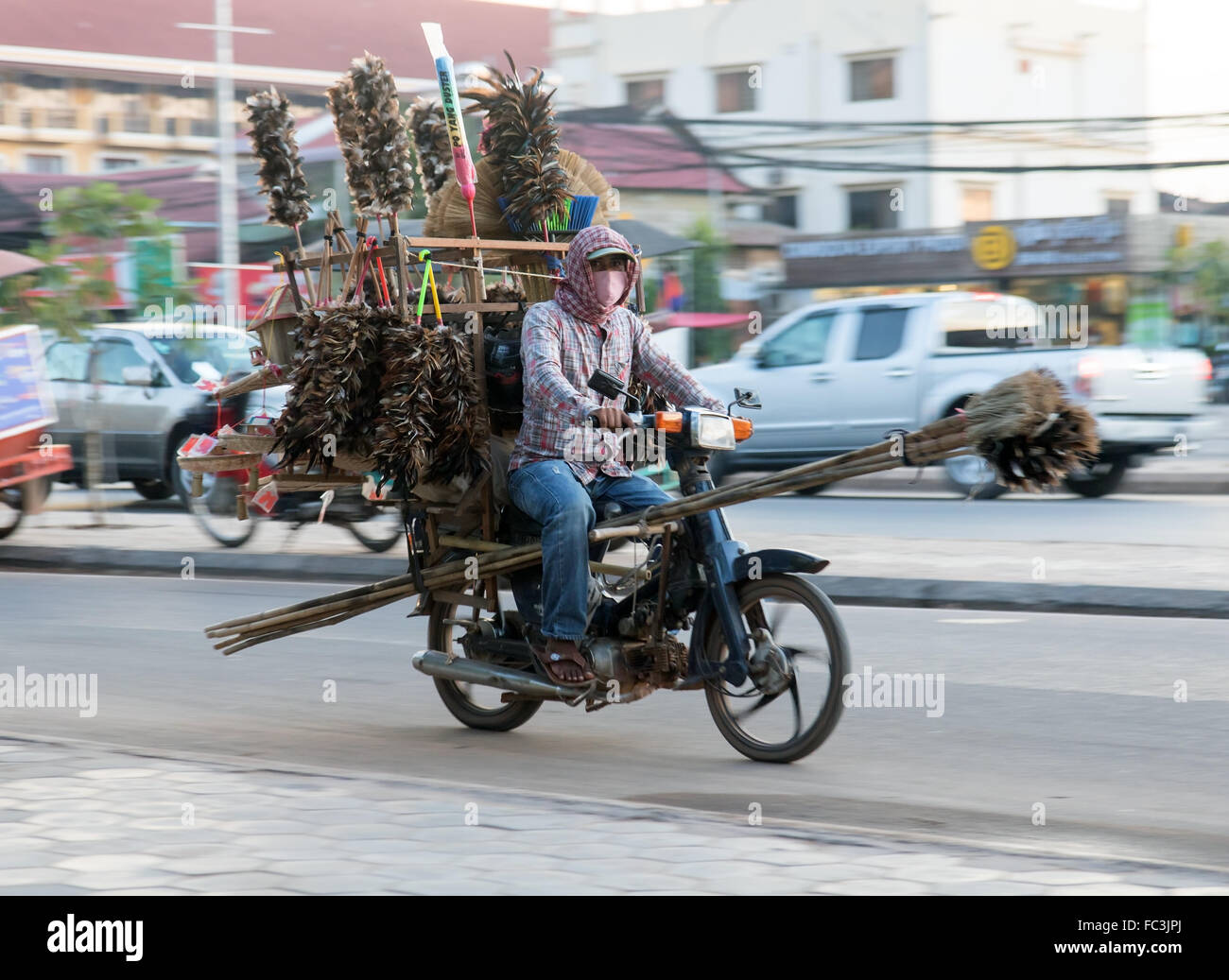 man on a motorcycle carrying brooms Stock Photo - Alamy