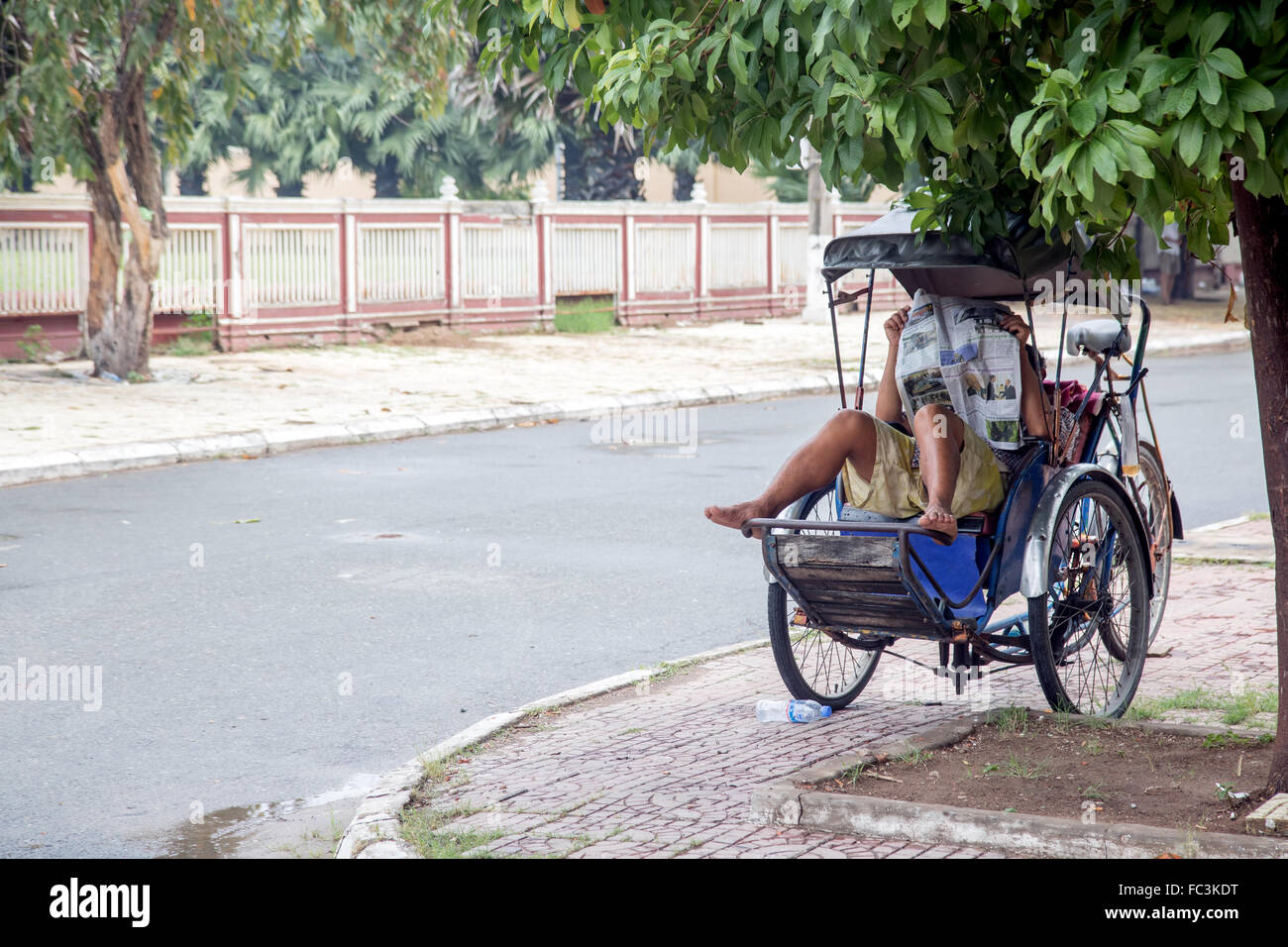 rickshaw driver reading a newspaper Stock Photo - Alamy
