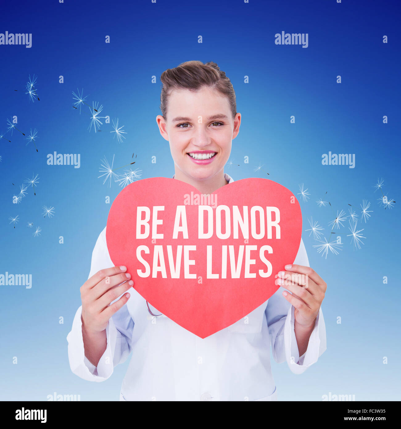 Composite image of smiling doctor holding heart card Stock Photo - Alamy