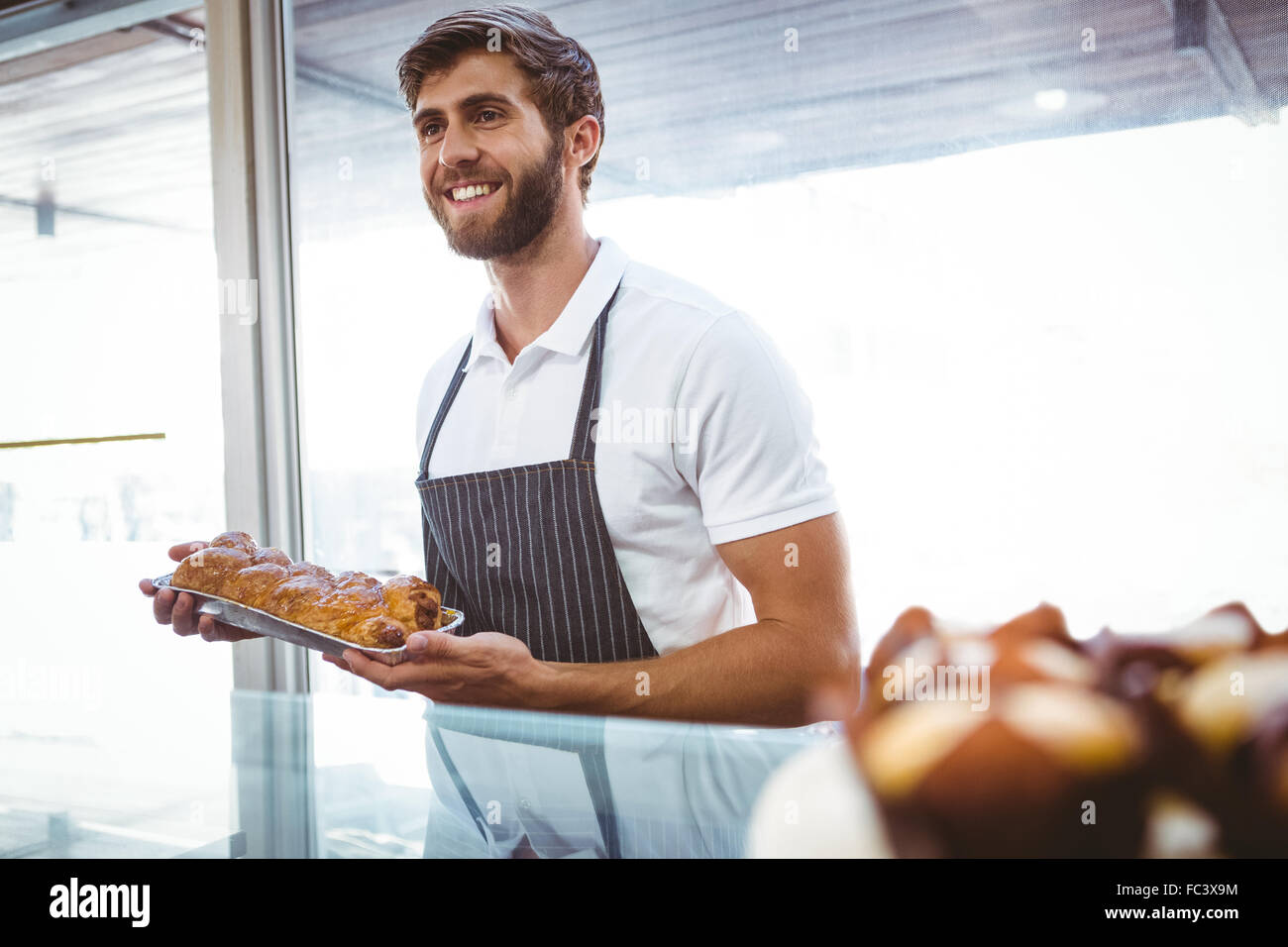 Portrait of smiling worker showing basket of bread Stock Photo - Alamy