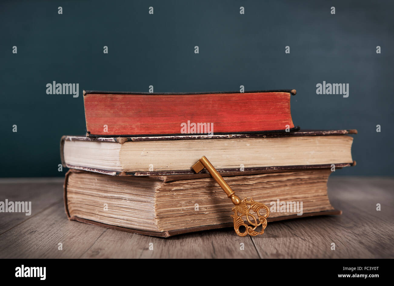 old books with a key locked against a dark background Stock Photo - Alamy