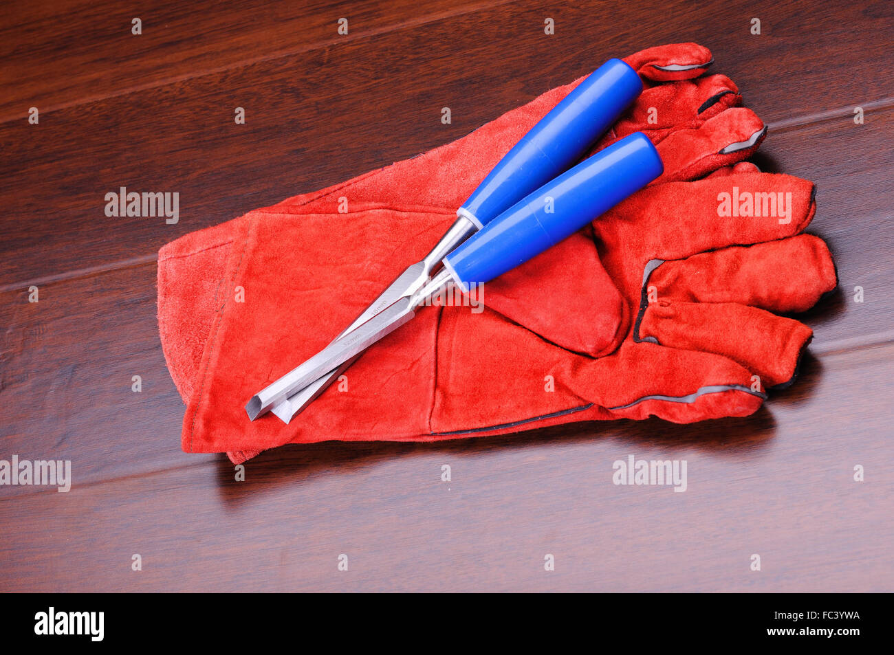Gloves for working in red and blue tools Stock Photo - Alamy