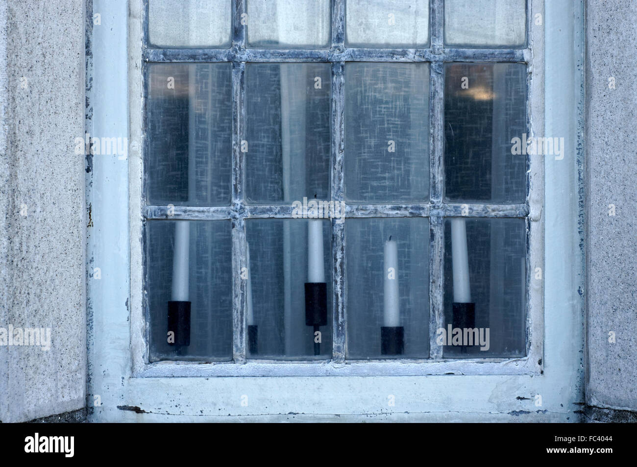 White candlesticks on the sill of paned leaded glass windows Stock ...