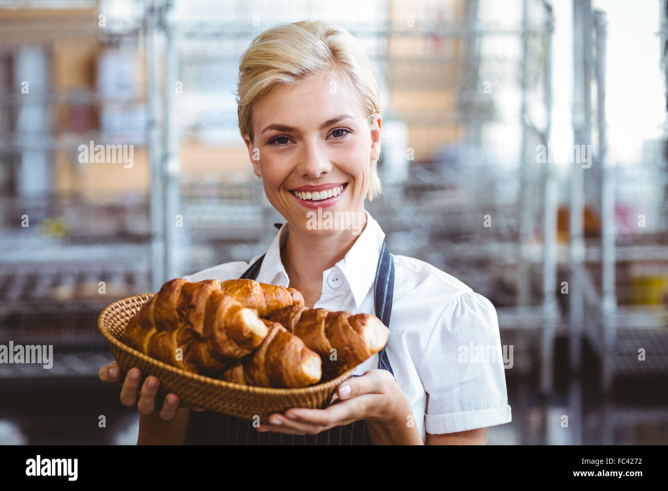 Cheerful gorgeous waitress holding a basket with croissant Stock Photo ...