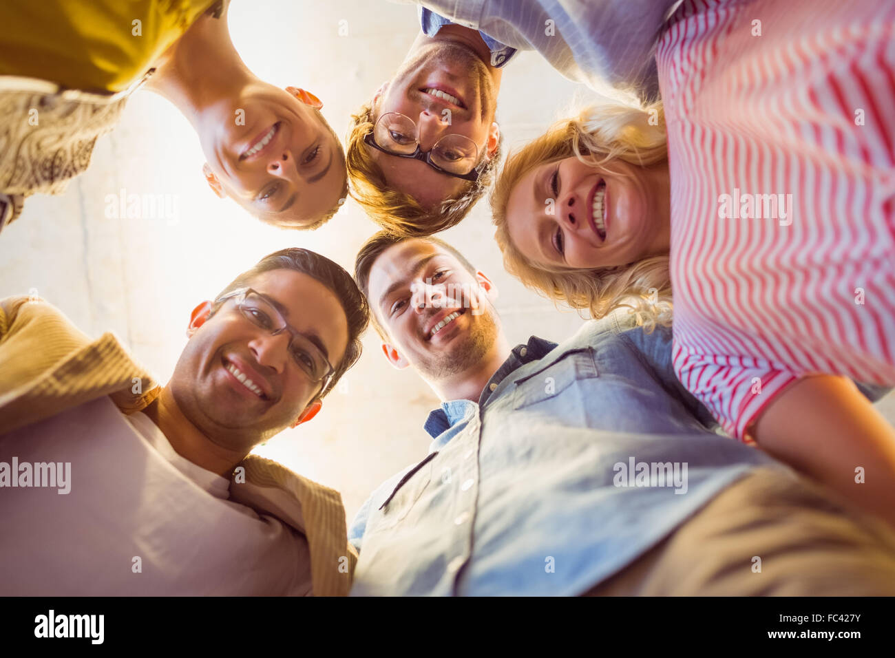 Business team standing in circle smiling at camera Stock Photo - Alamy