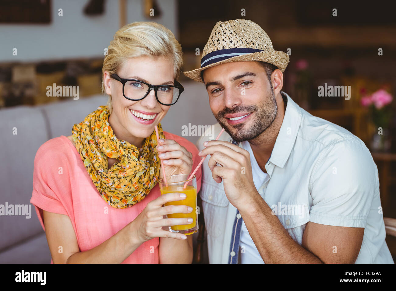 Cute couple on a date sharing an orange juice Stock Photo - Alamy
