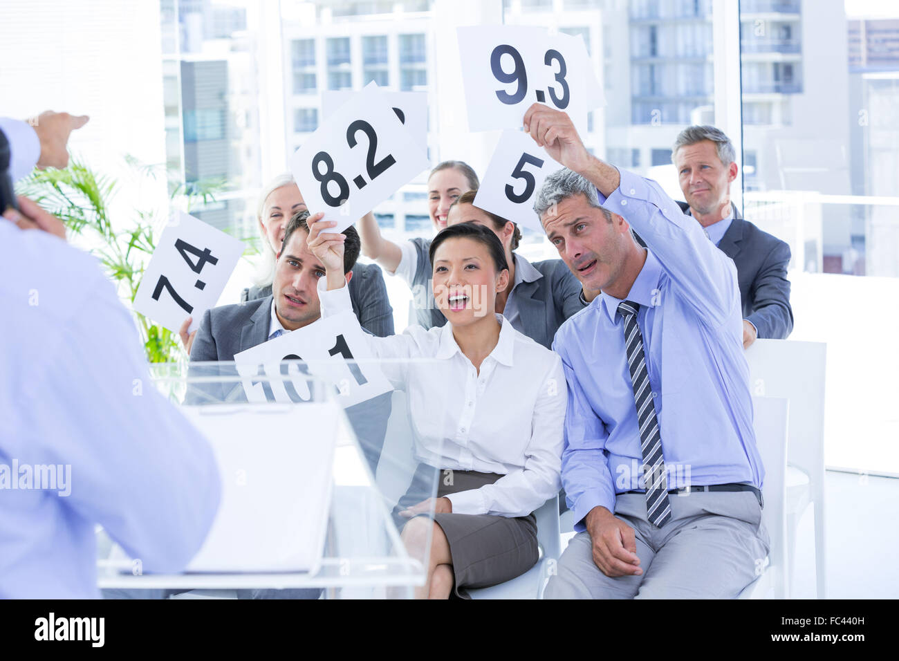 Smiling business team showing paper with rating Stock Photo - Alamy