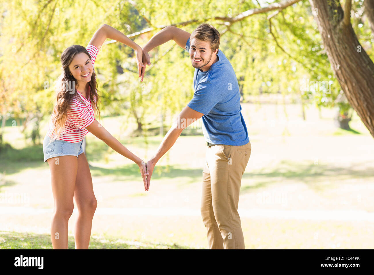 Cute couple doing heart shape with their hands Stock Photo - Alamy