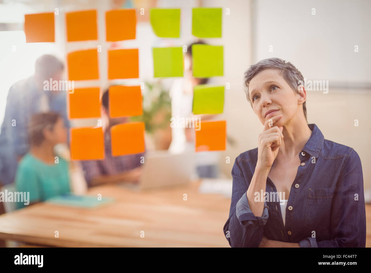 Concentrated businesswoman looking post its on the wall Stock Photo - Alamy