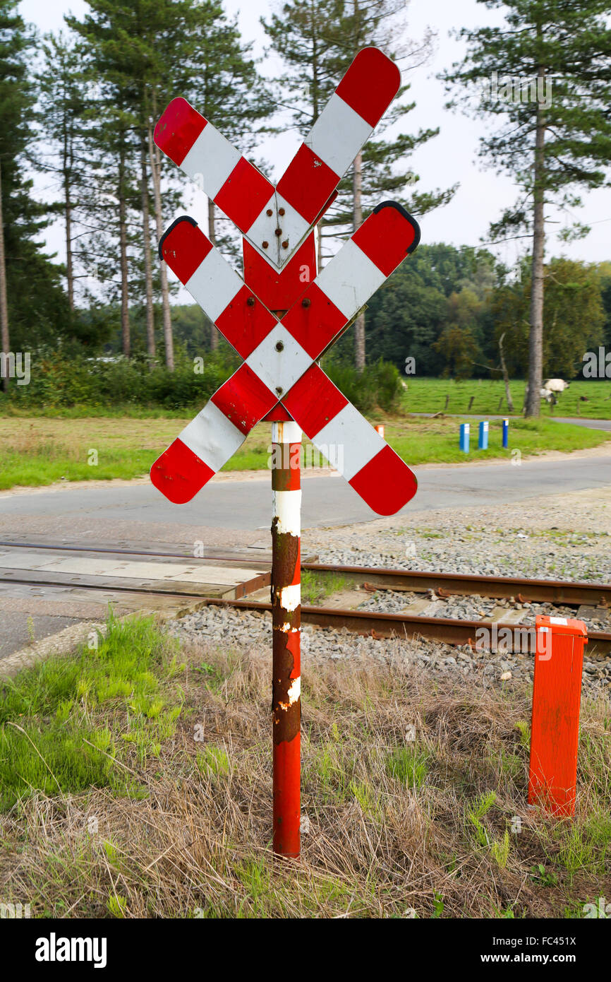 Red and white railroad crossing sign and road Stock Photo - Alamy