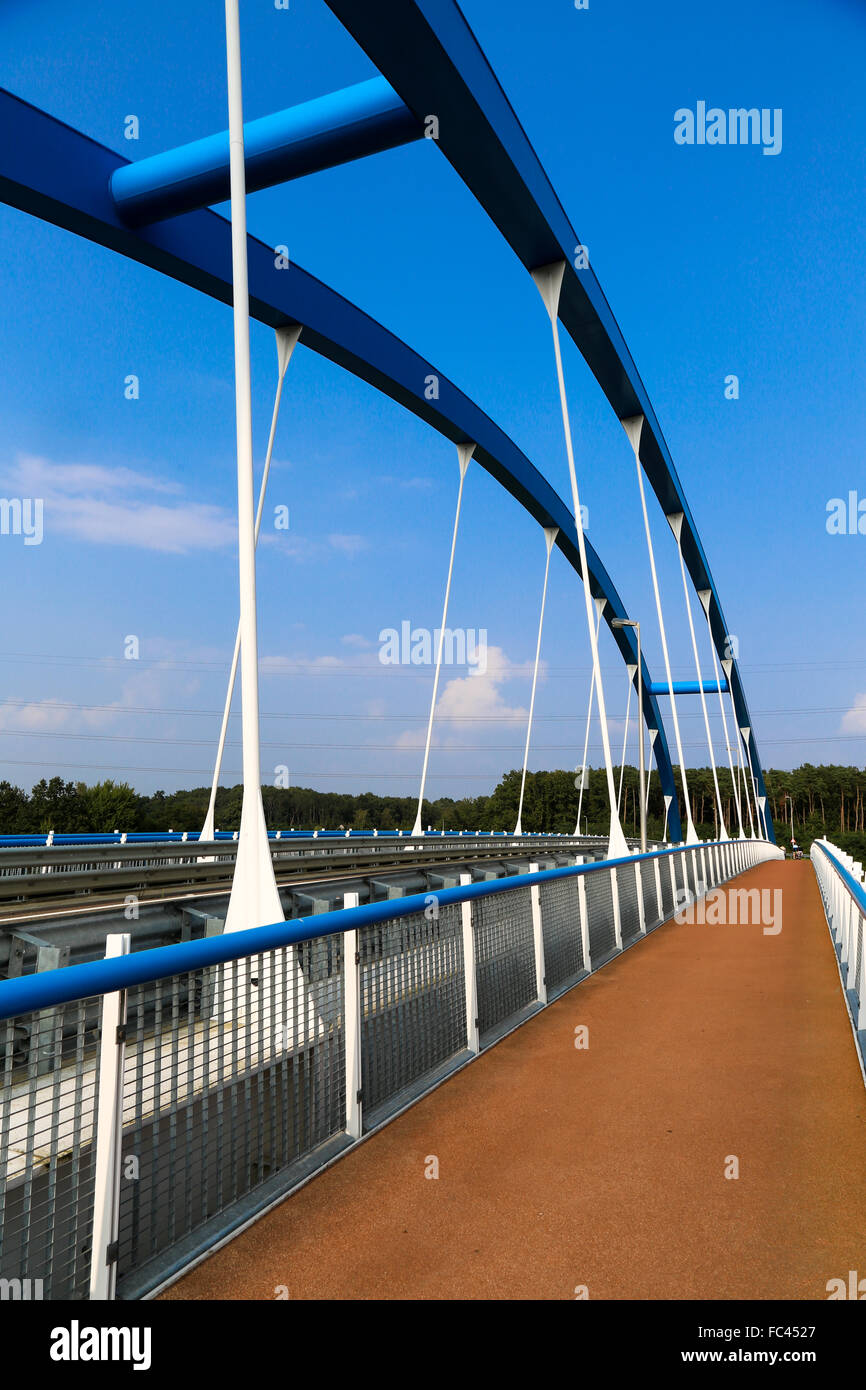 A blue steel structure of a bridge crossing a river Stock Photo - Alamy