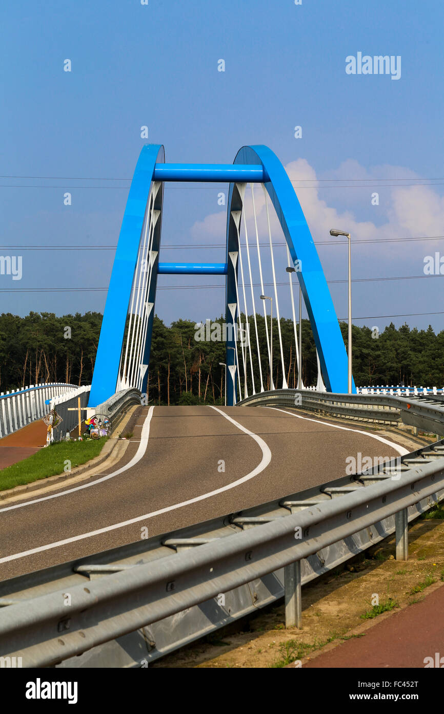 A blue steel structure of a bridge crossing a river Stock Photo - Alamy