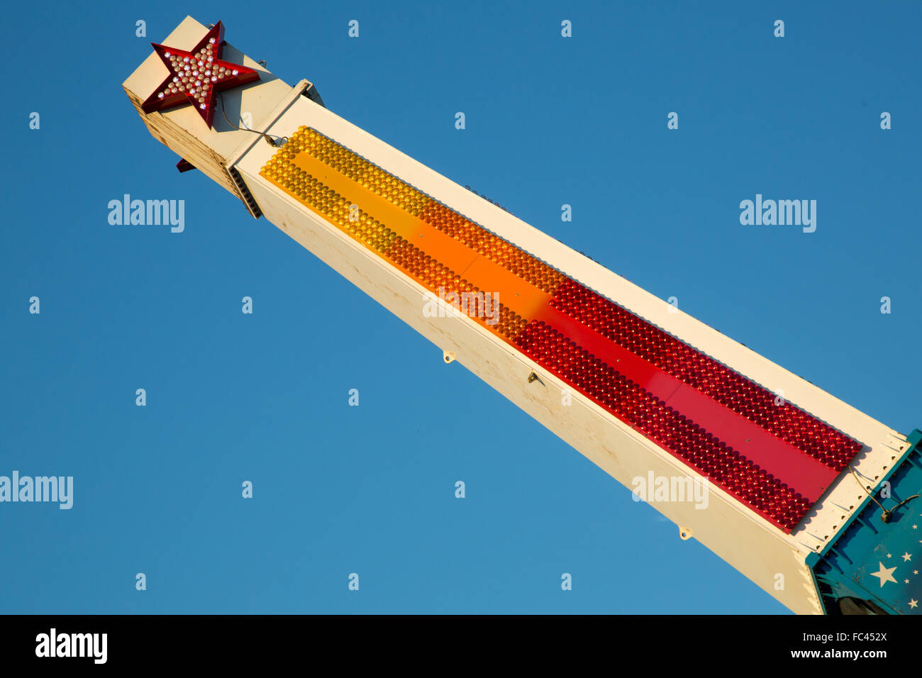 A fair ride with neon colors at a blue sky Stock Photo - Alamy