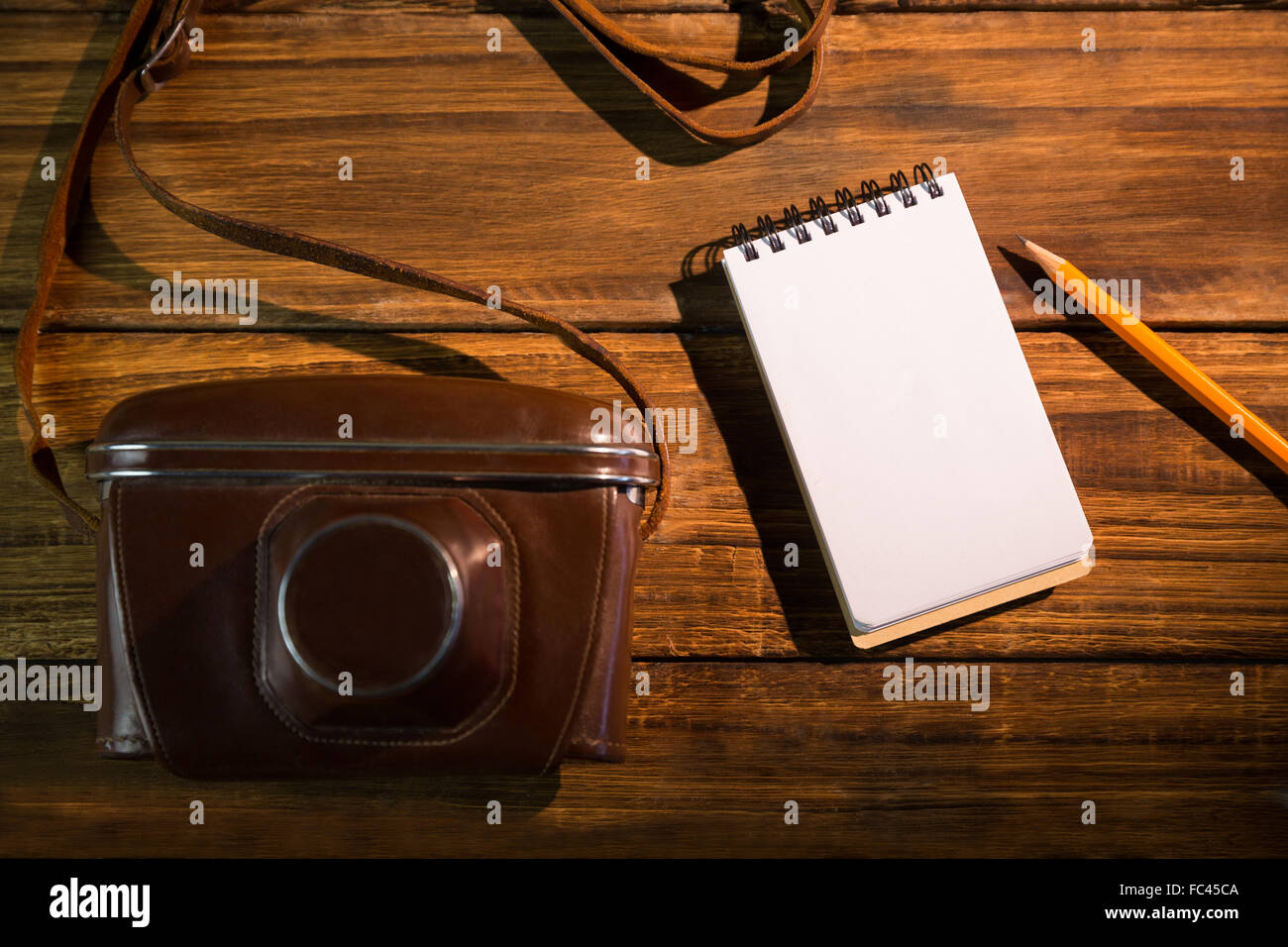 Notepad next to camera and pen Stock Photo - Alamy