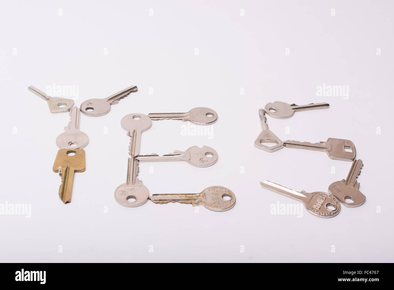 Old keys arranged on a while background Stock Photo - Alamy
