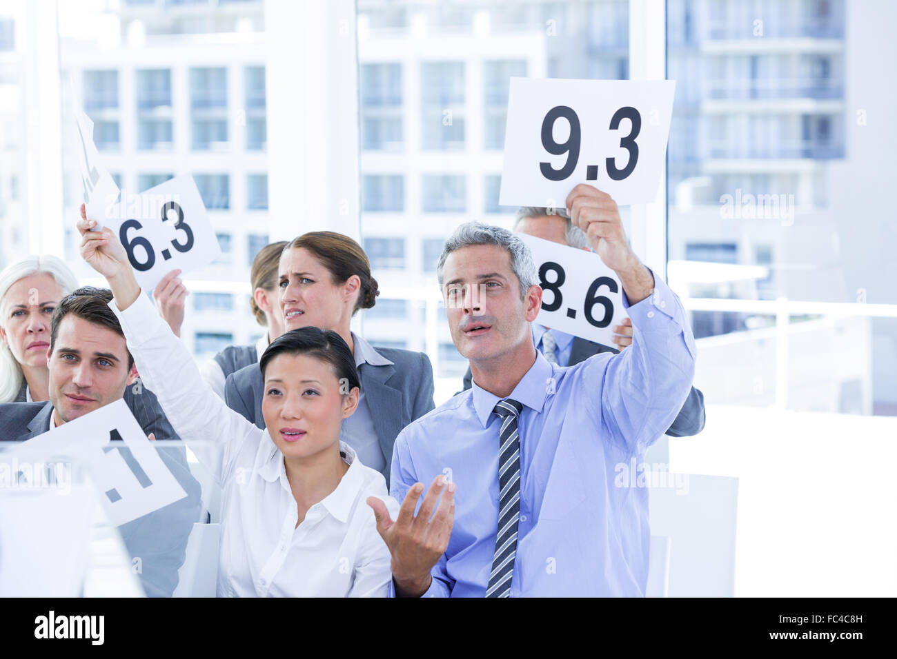 Smiling business team showing paper with rating Stock Photo - Alamy