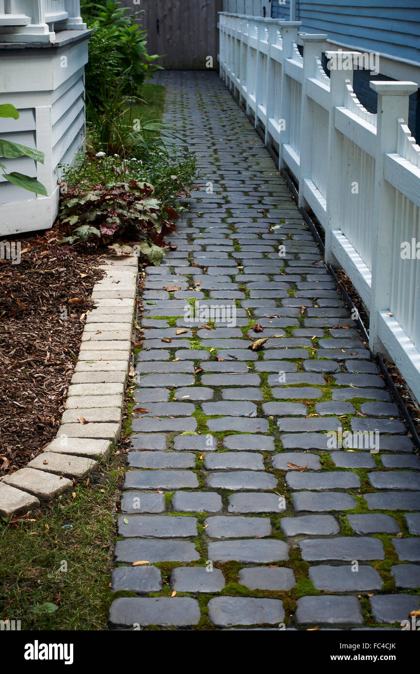 Cobblestone path along fence Stock Photo - Alamy