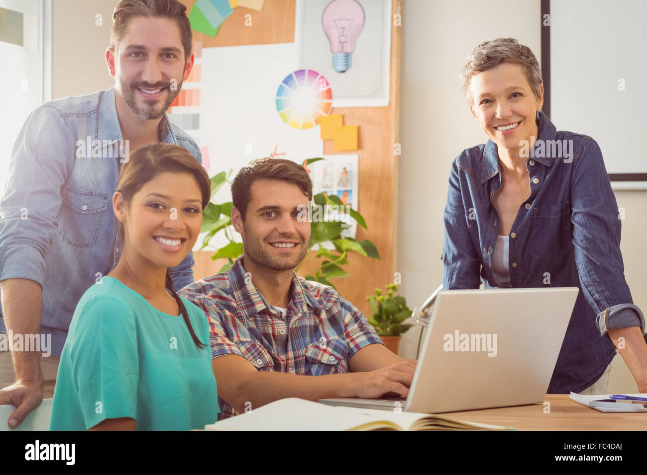 Colleagues using laptop at office Stock Photo - Alamy