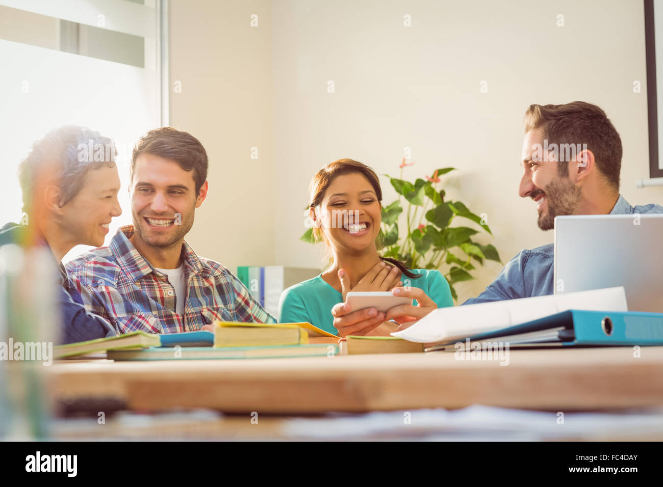 Groups of colleague looking at the smartphone Stock Photo - Alamy