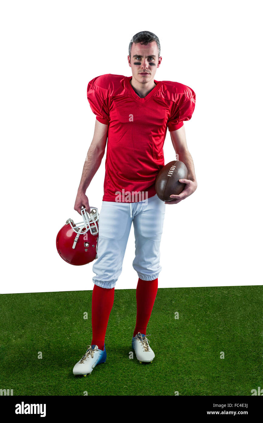 A serious american football player taking his helmet on her hand ...