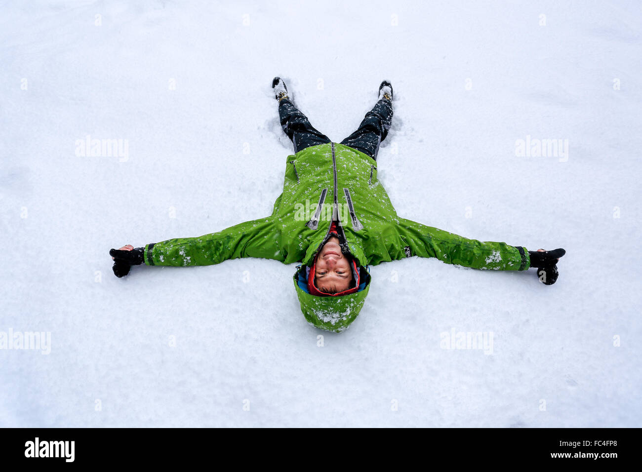 Top view young man lying on the snow Stock Photo - Alamy