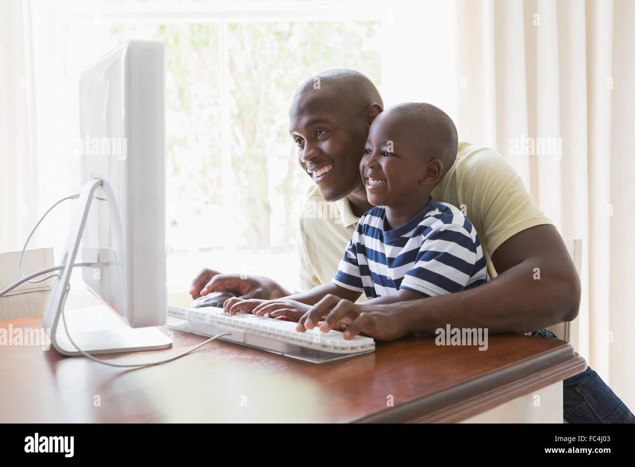 Happy smiling father with his son using computer Stock Photo - Alamy