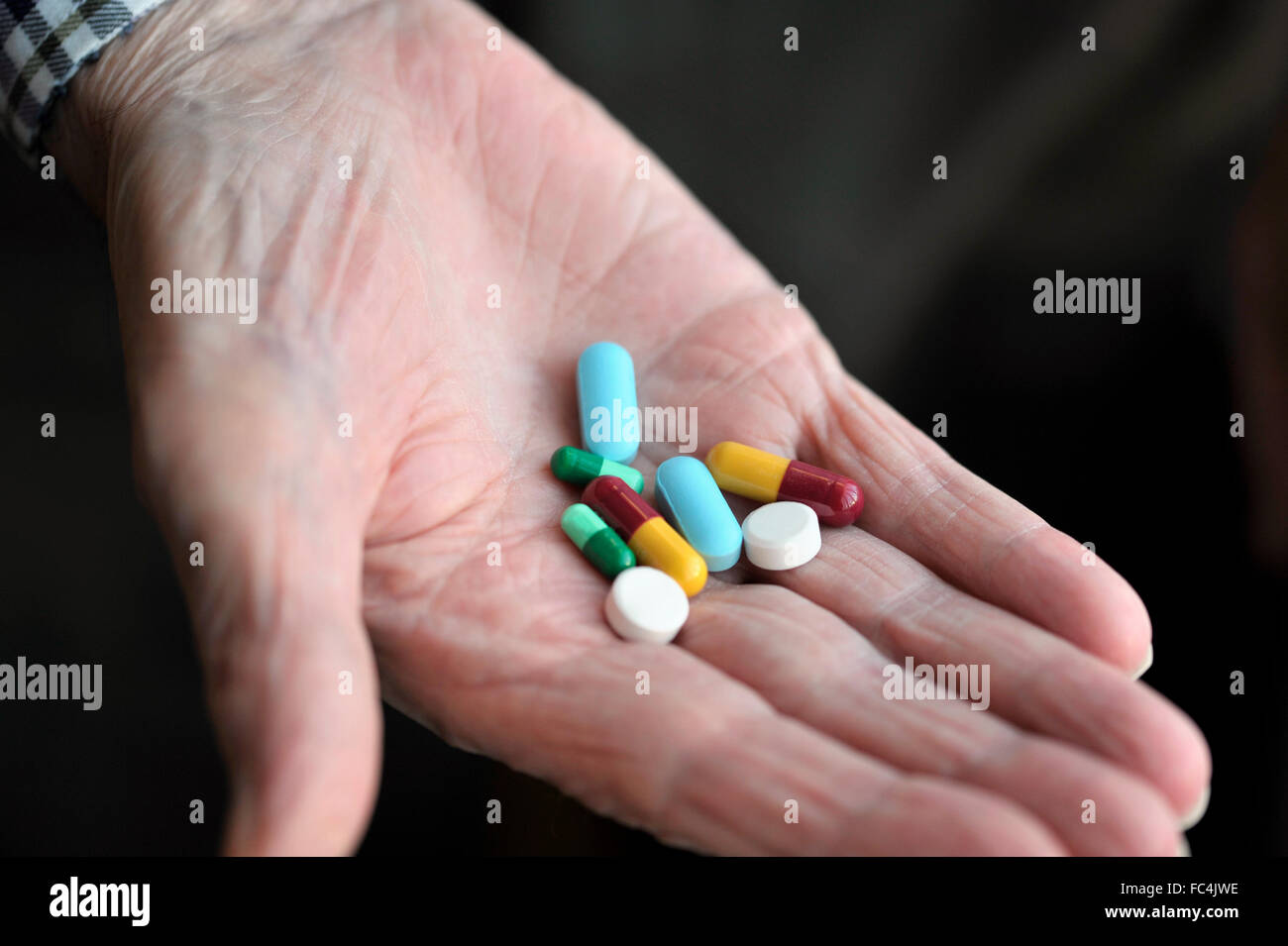 Old person holding medicine, drugs in hand Stock Photo - Alamy